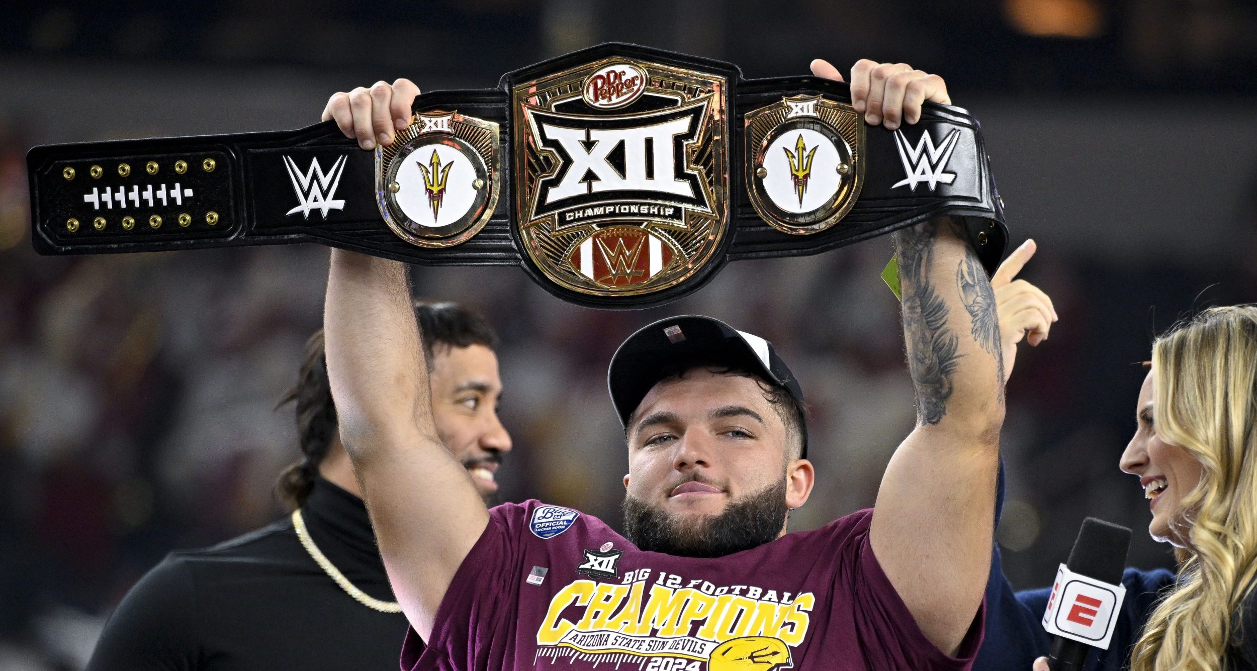 A WWE logo on the Big 12 Championship belt held by former Arizona State running back Cam Skattebo