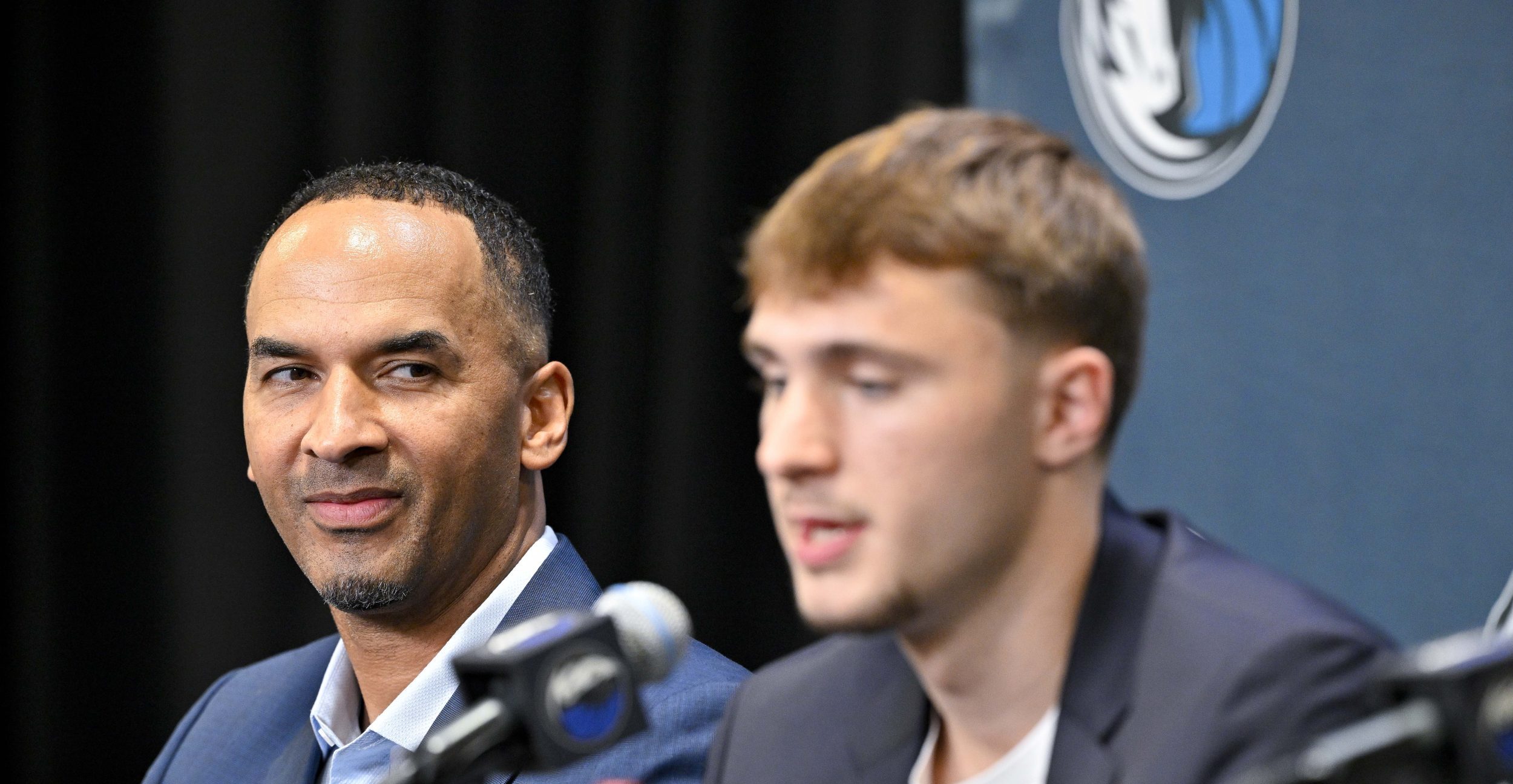 Jun 27, 2025; Dallas, TX, USA; Dallas Mavericks general manager Nico Harrison (left) looks on with Mavericks first overall pick Cooper Flagg (right) at a press conference at the Dallas Mavericks Practice Facility.